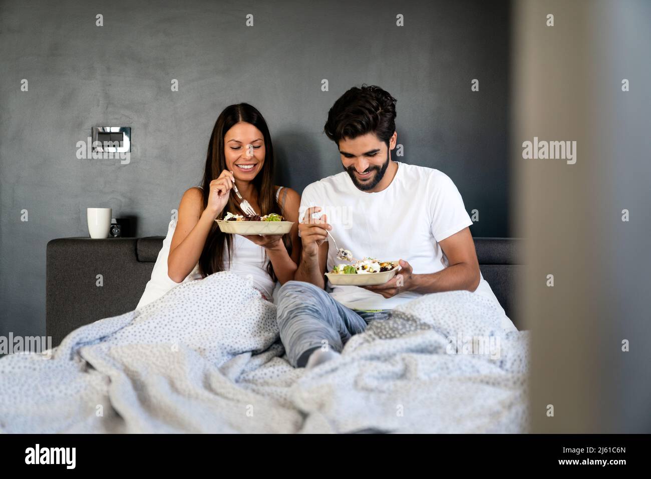 Healthy breakfast in bed. Young beautiful couple in love spending time ...