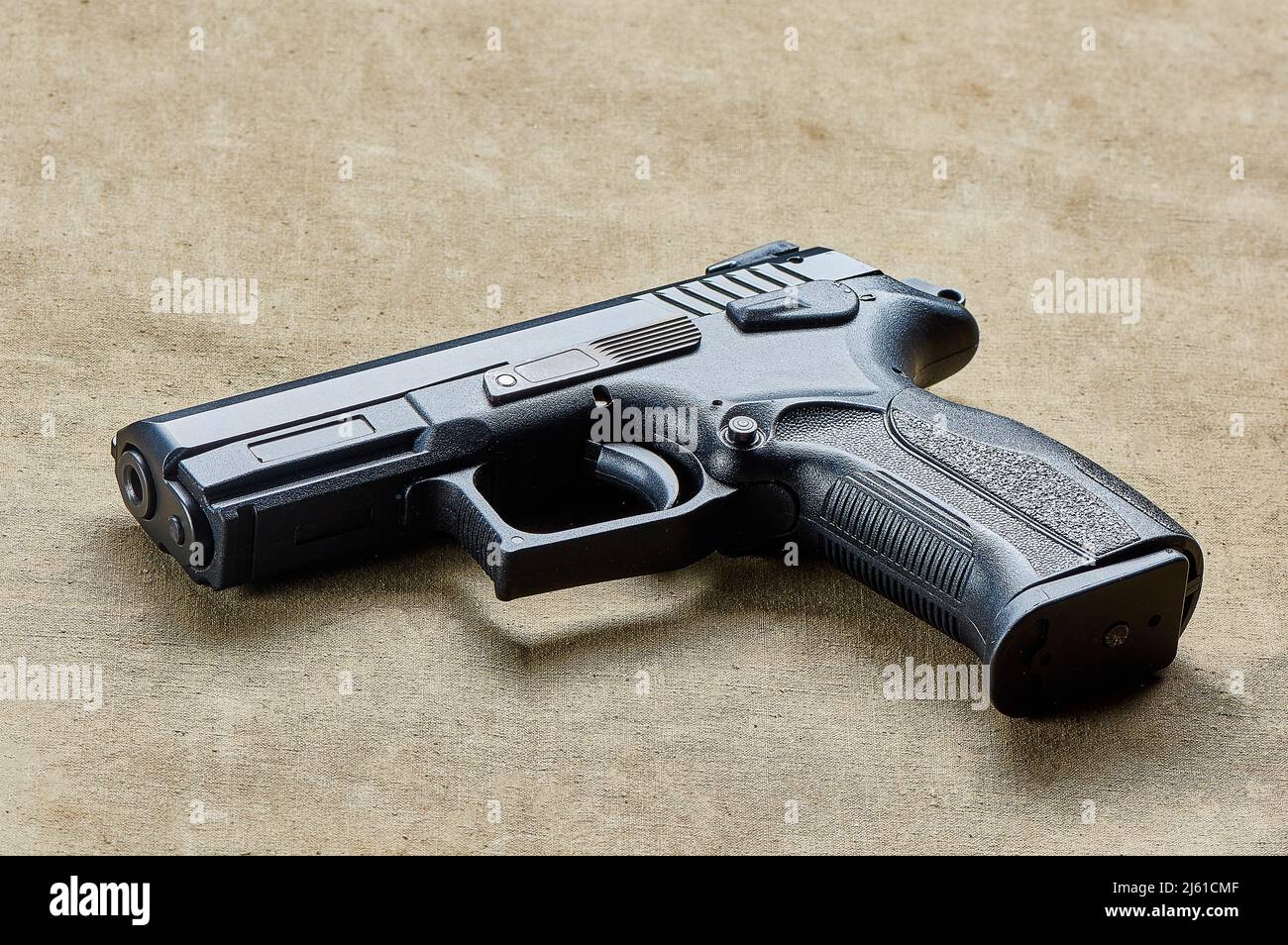 A black pistol in close-up lies on a canvas background, a firearm Stock ...