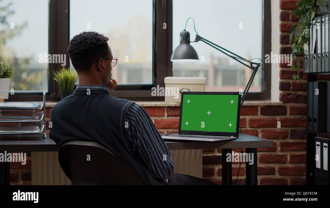 Business man working with laptop and green screen on display, using ...