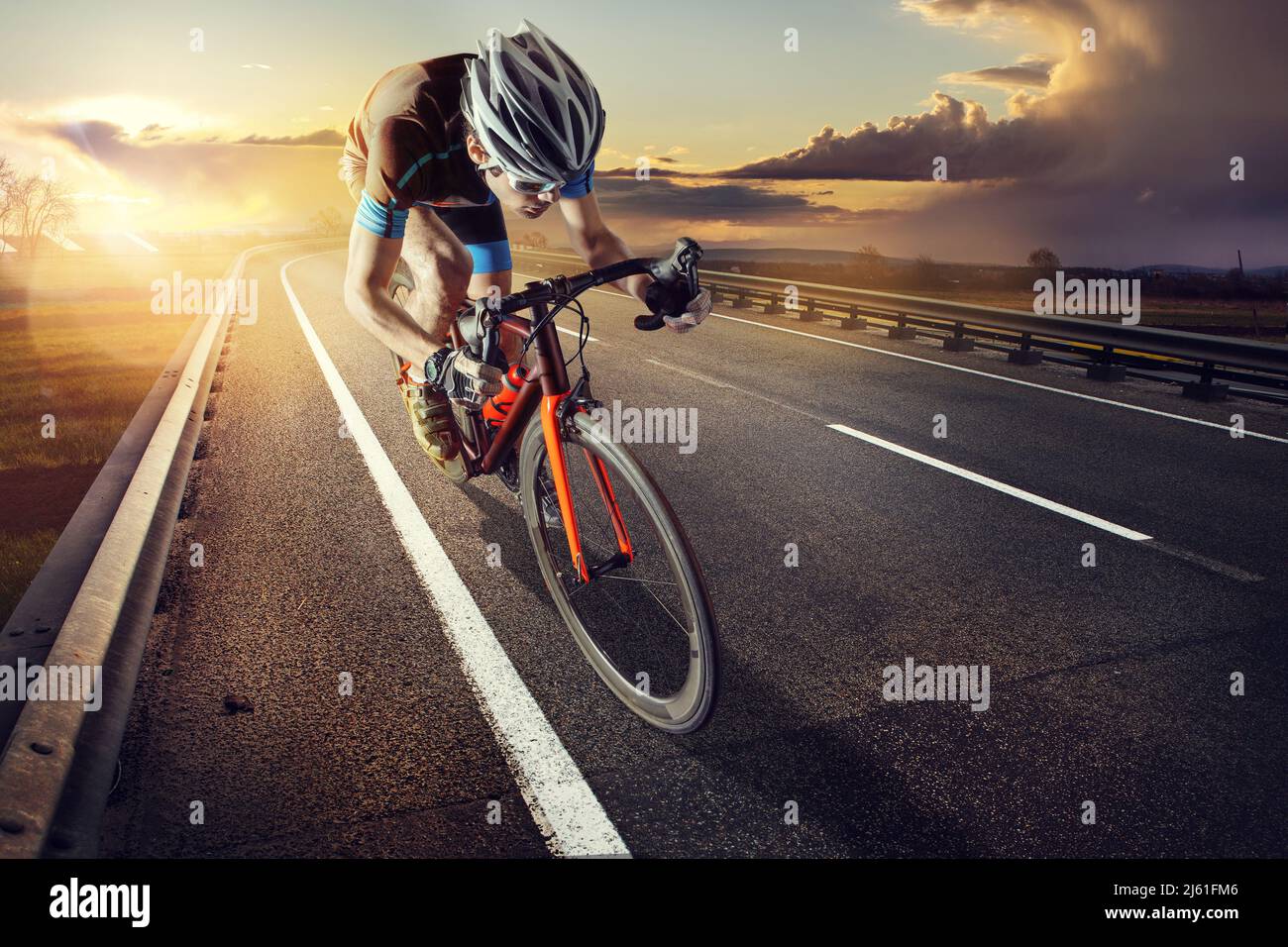 The cyclist rides on his bike at sunset. Dramatic background Stock ...