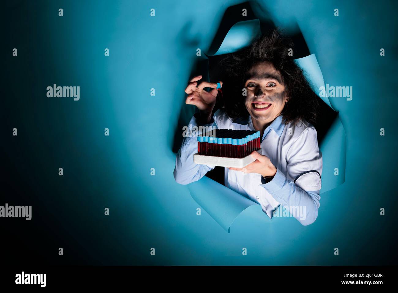 Crazy goofy scientist having tray with glass test tubes filled with ...