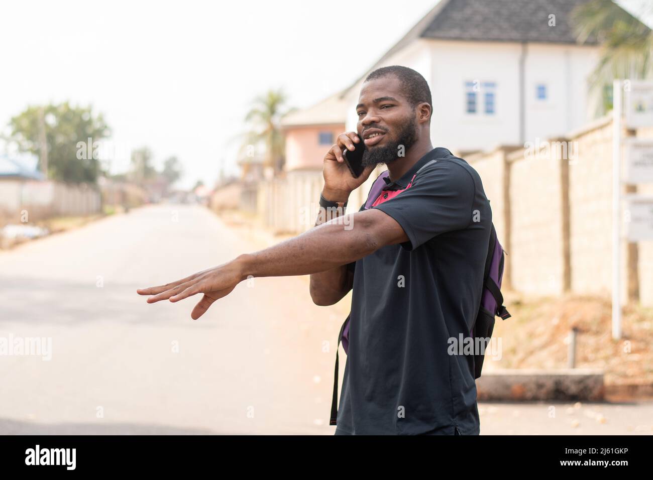 african man making a phone call, hailing a cab Stock Photo - Alamy