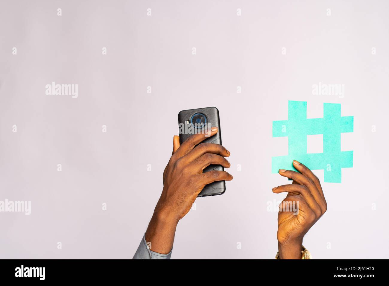 black person holding phone and hash tag symbol Stock Photo - Alamy