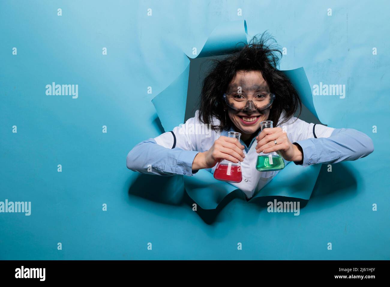 Crazy silly chemist with dirty face and wacky hairstyle holding glass ...