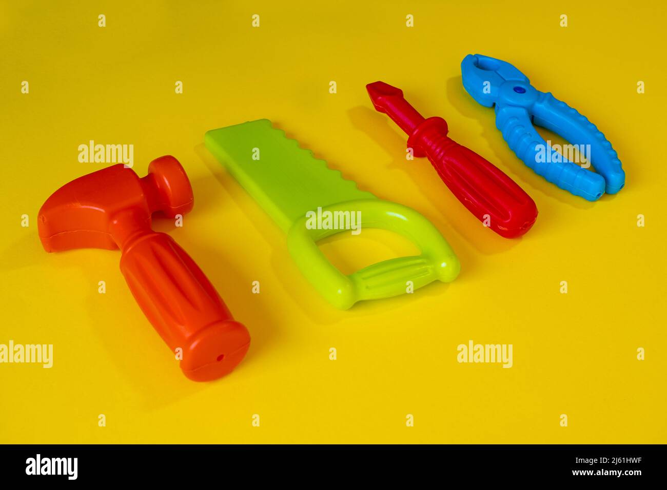 Colorful repair toys on yellow background, child's play isolated on ...