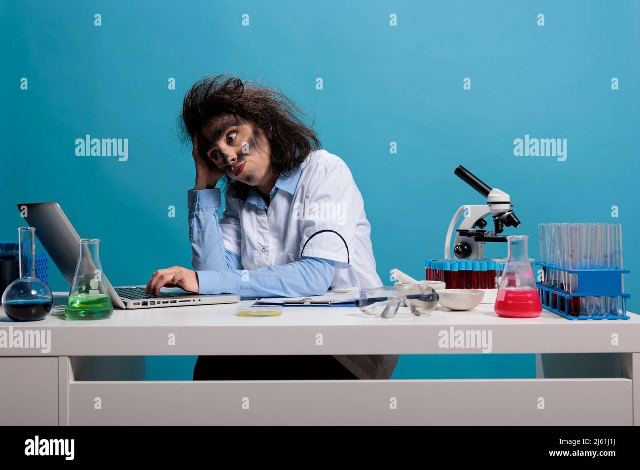 Wild foolish woman with dirty face researching discovery on laptop ...