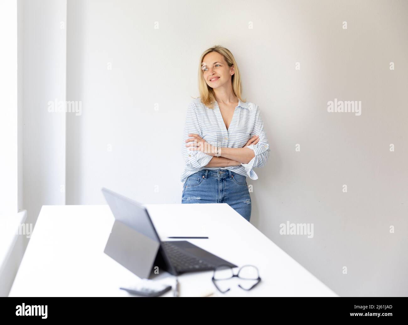 portrait of pretty young blonde business woman standing by her ...