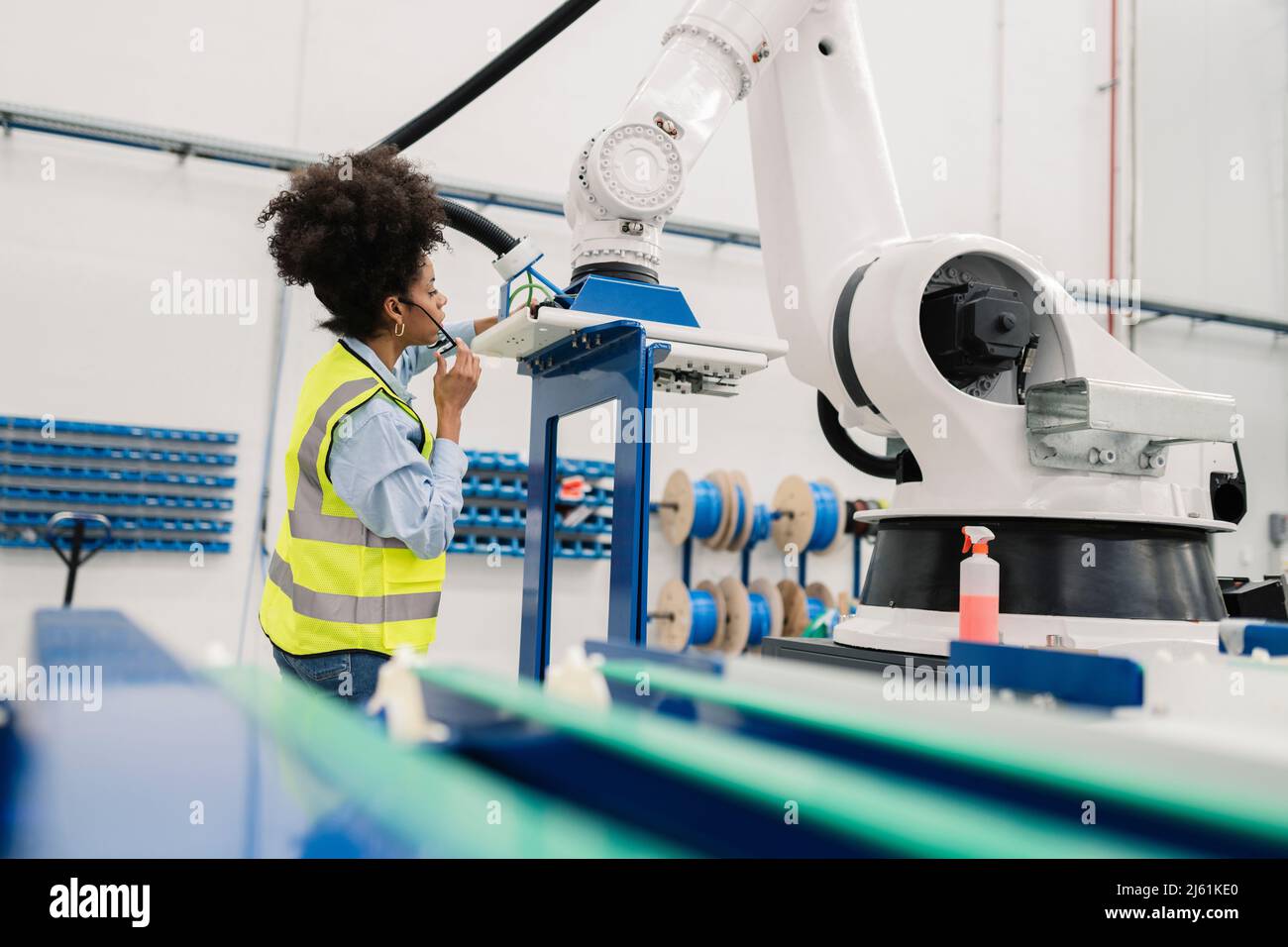 Engineer analyzing robotic arm machine in factory Stock Photo - Alamy