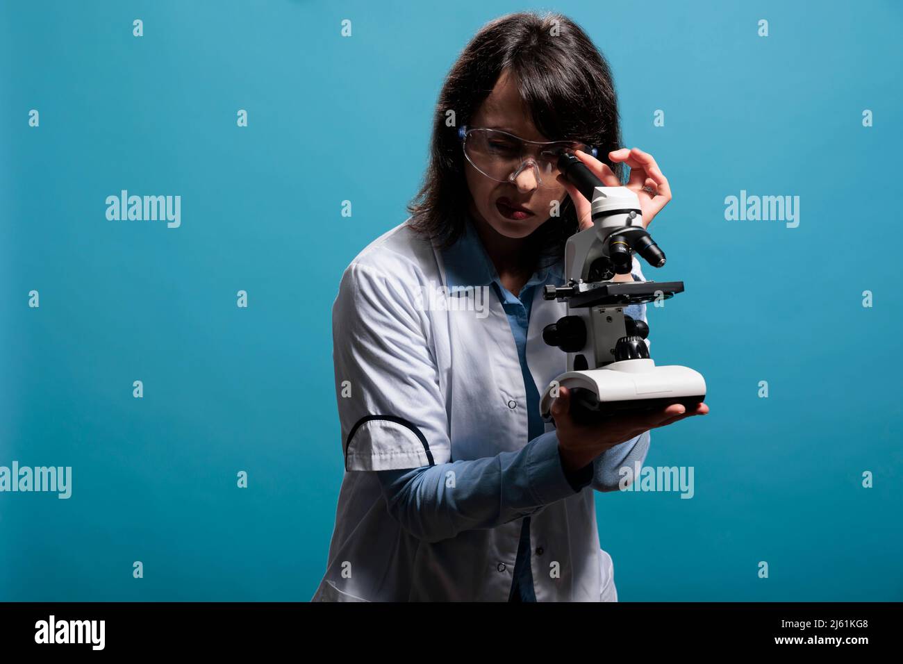 Microbiology expert using modern microscope to analyze virus at ...