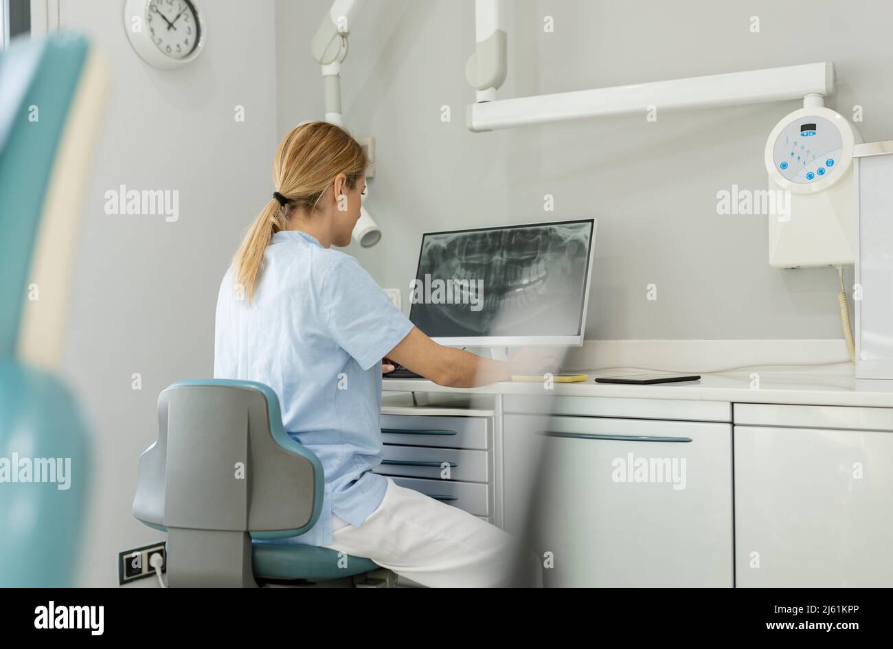 Dentist examining x-ray image on computer desktop at dental clinic ...