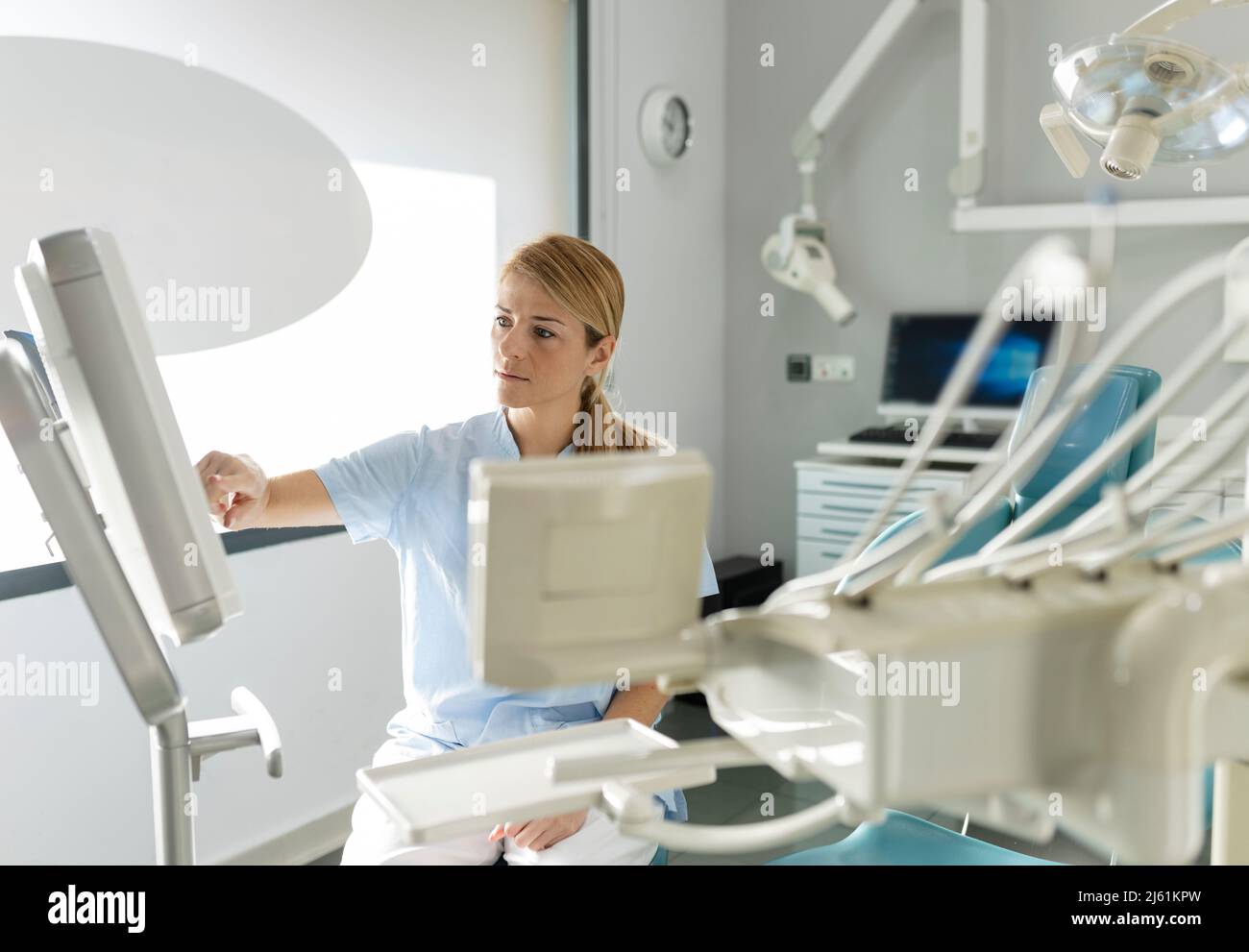 Dentist touching on monitor screen at dental clinic Stock Photo - Alamy