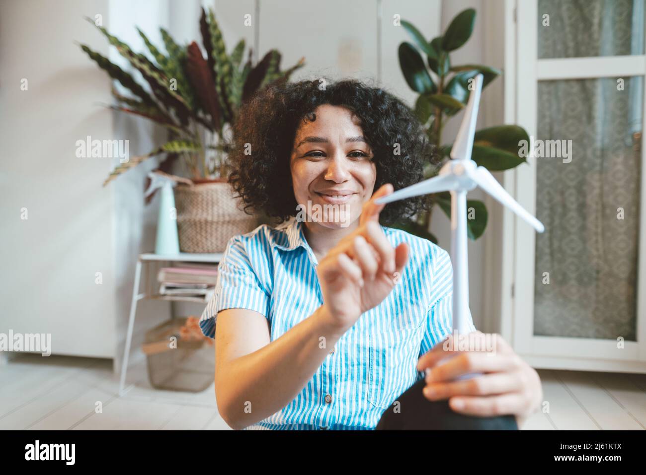 Smiling woman touching windmill model at home Stock Photo - Alamy