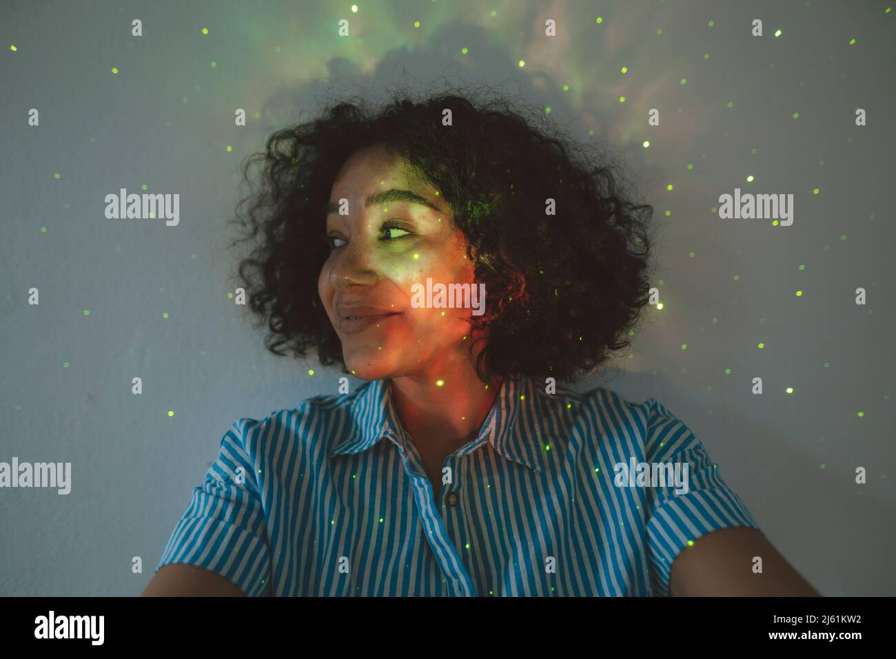 Astro light effect falling on face of smiling woman in front of wall ...