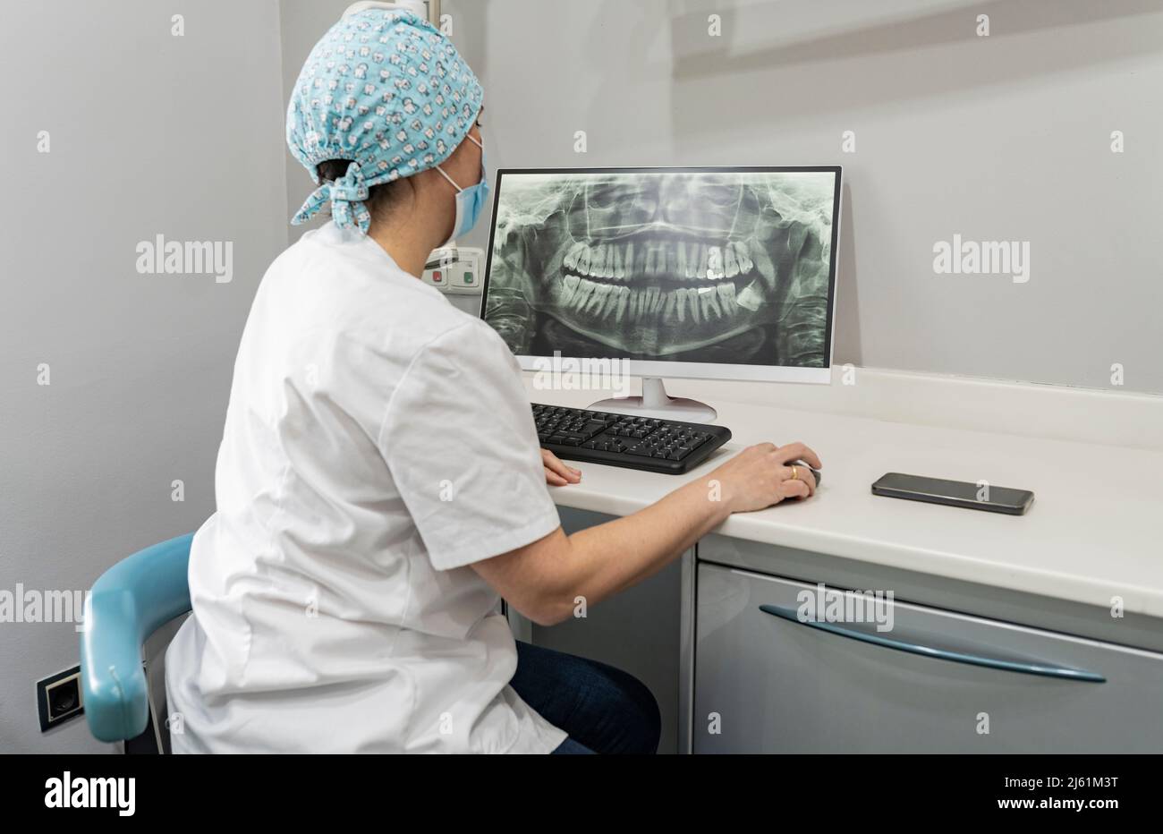 Dentist examining x-ray image on computer at dental clinic Stock Photo ...