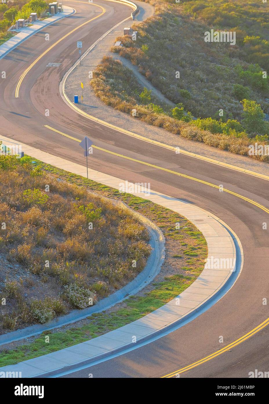 Vertical High angle view of a winding road with road intersection sign ...