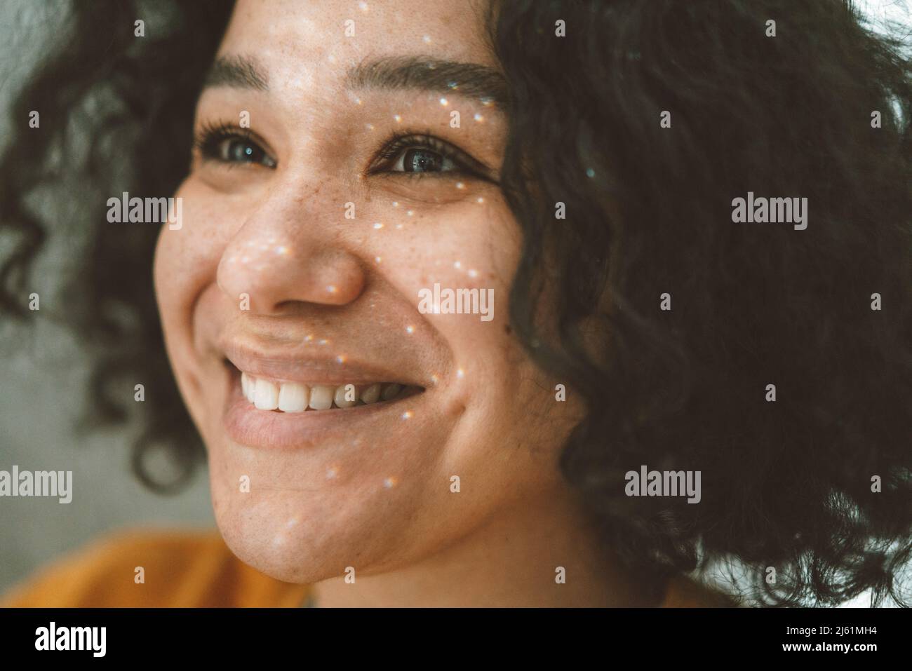 Smiling beautiful woman with light on face Stock Photo - Alamy