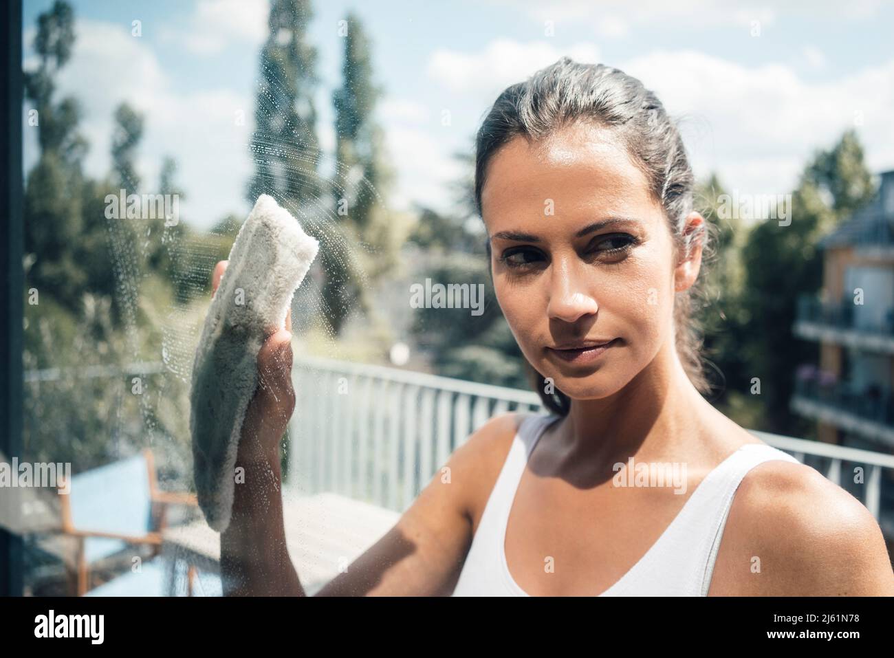 Woman cleaning glass window on sunny day Stock Photo - Alamy