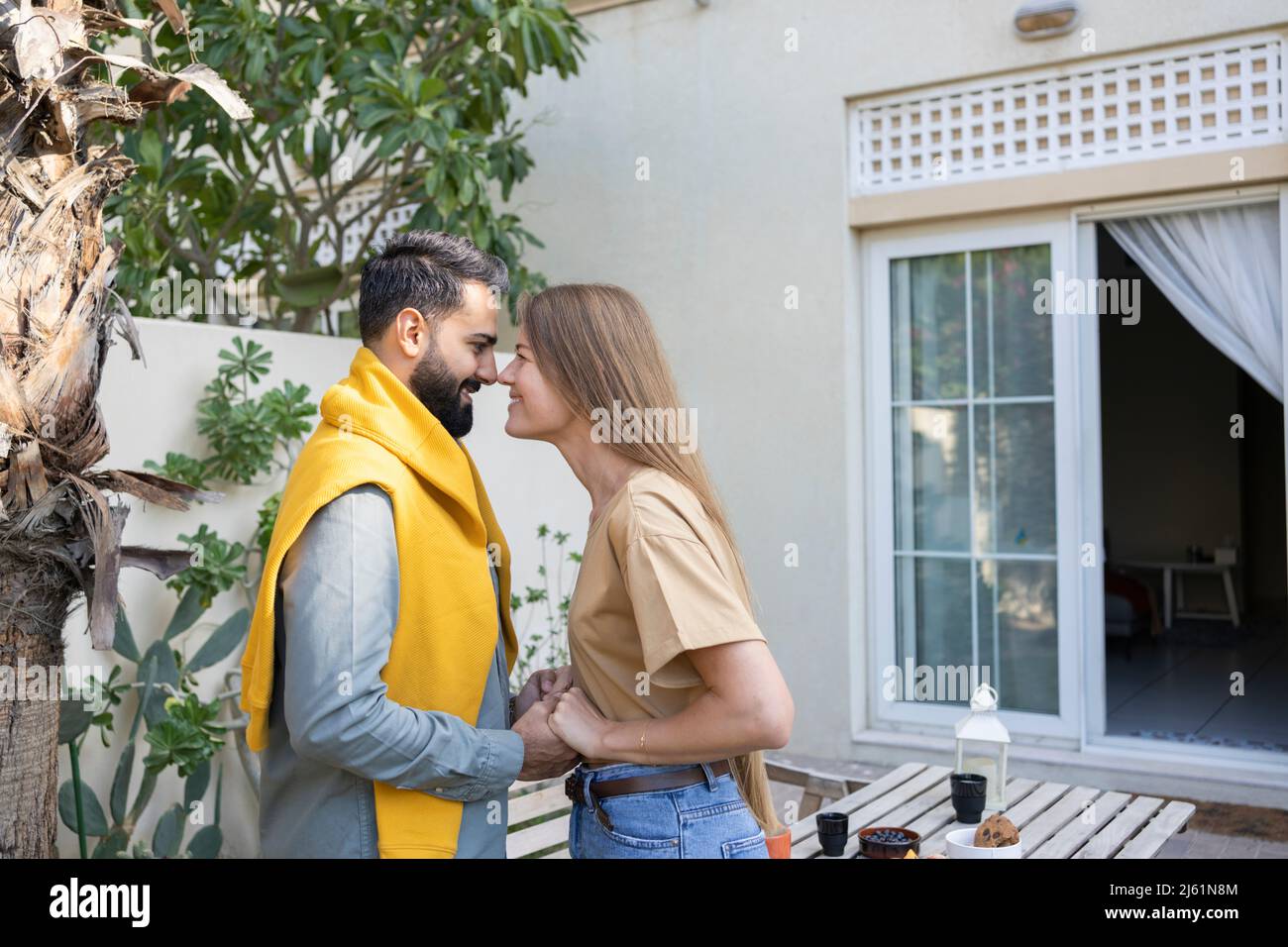 Happy couple rubbing nose together standing in front of house Stock ...