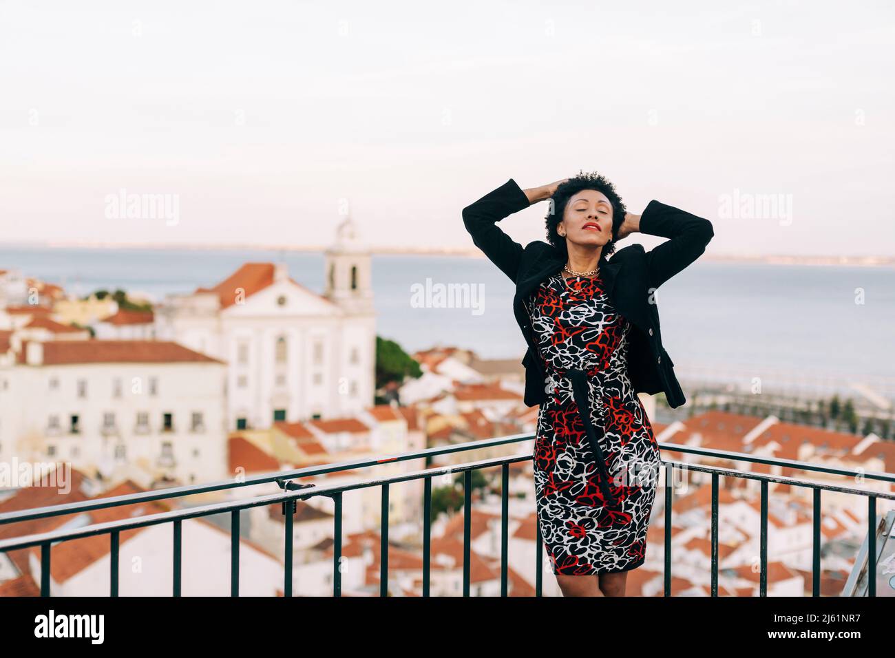 Woman with hands behind head in balcony Stock Photo - Alamy