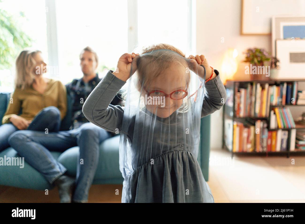 Cute little girl wearing eyeglasses playing in living room at home ...