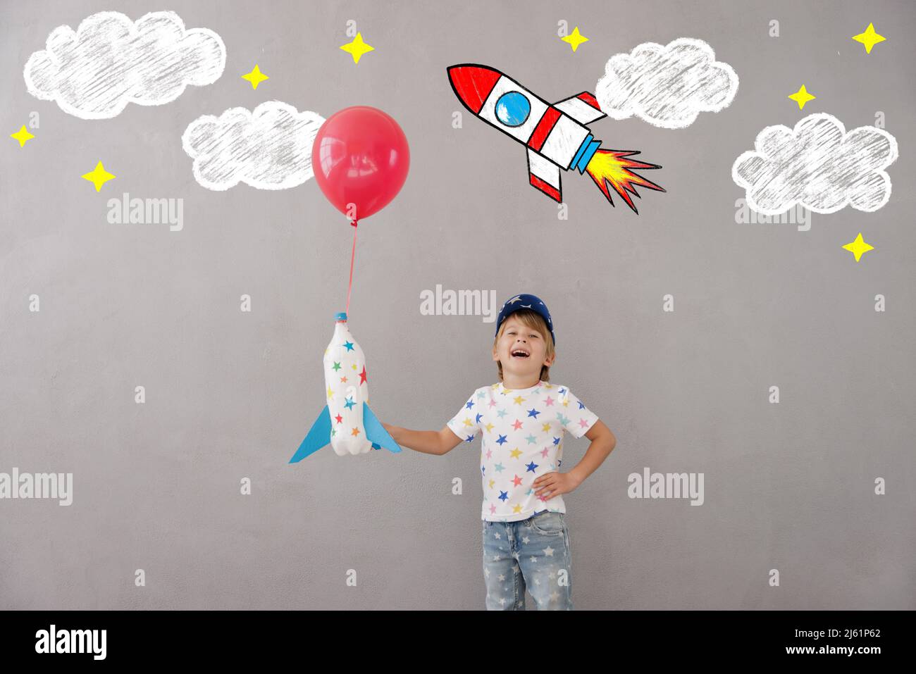 Happy child playing with toy rocket at home. Kid pretend to be ...