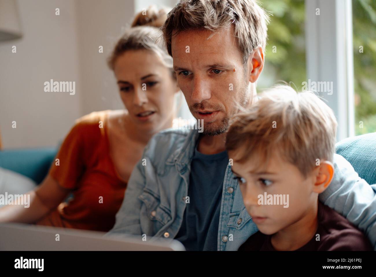 Family sharing laptop together at home Stock Photo - Alamy