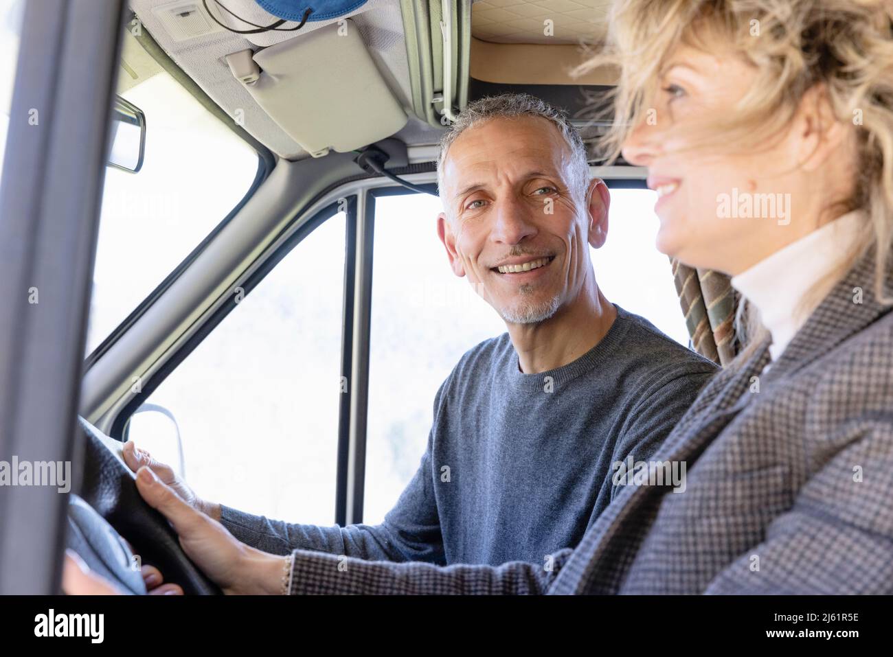 Man smiling at woman driving camper van Stock Photo - Alamy