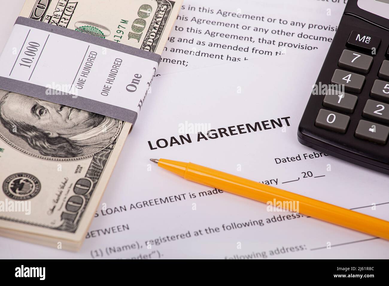 Mortgage. A pen, a wad of dollars and a calculator are on the loan ...