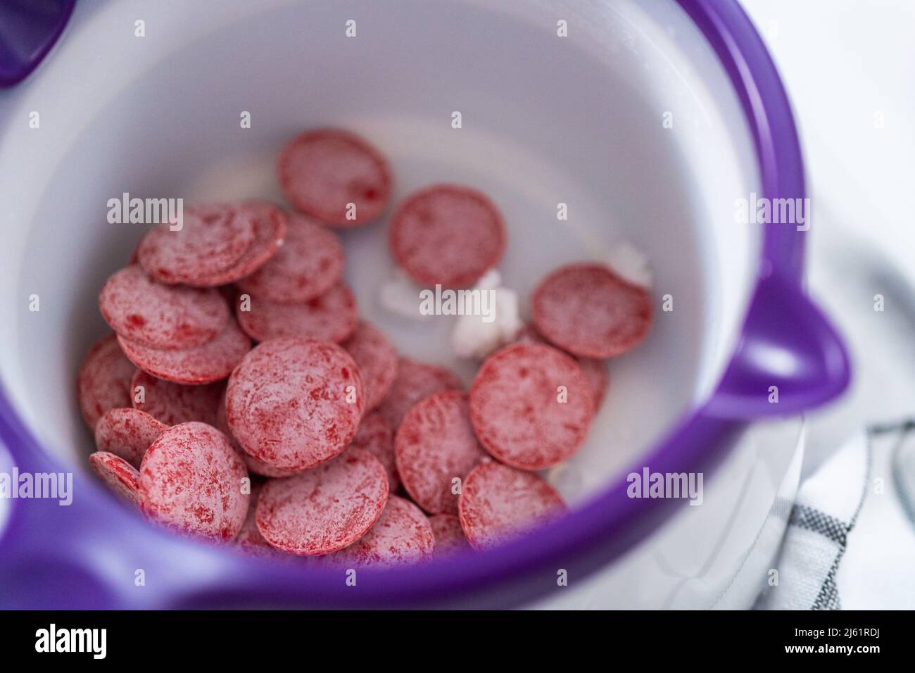 Melting color chocolate chips in electric candy melting pot Stock Photo ...