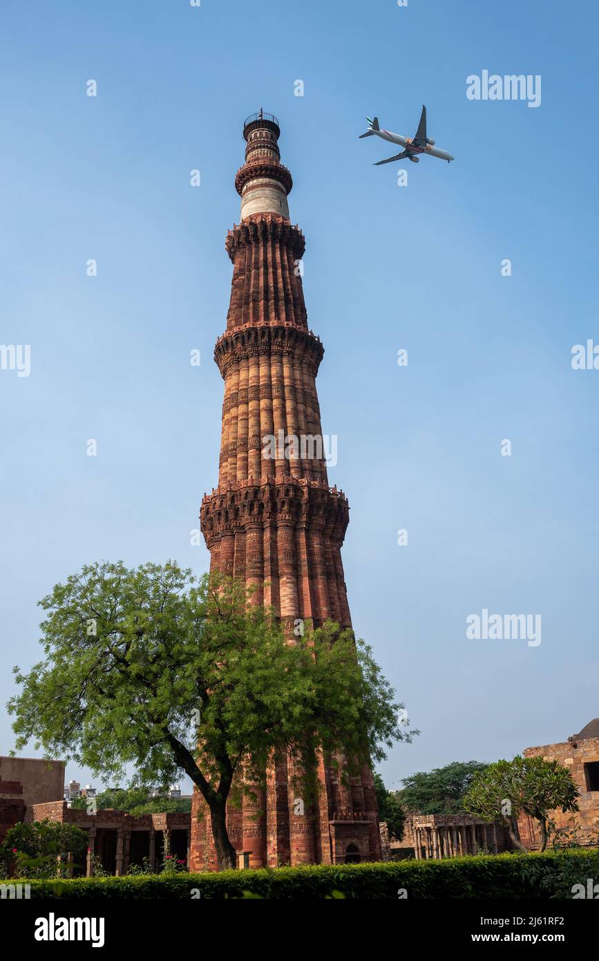 An airliner flying over Qutub Minar. The medieval meets modern Stock ...