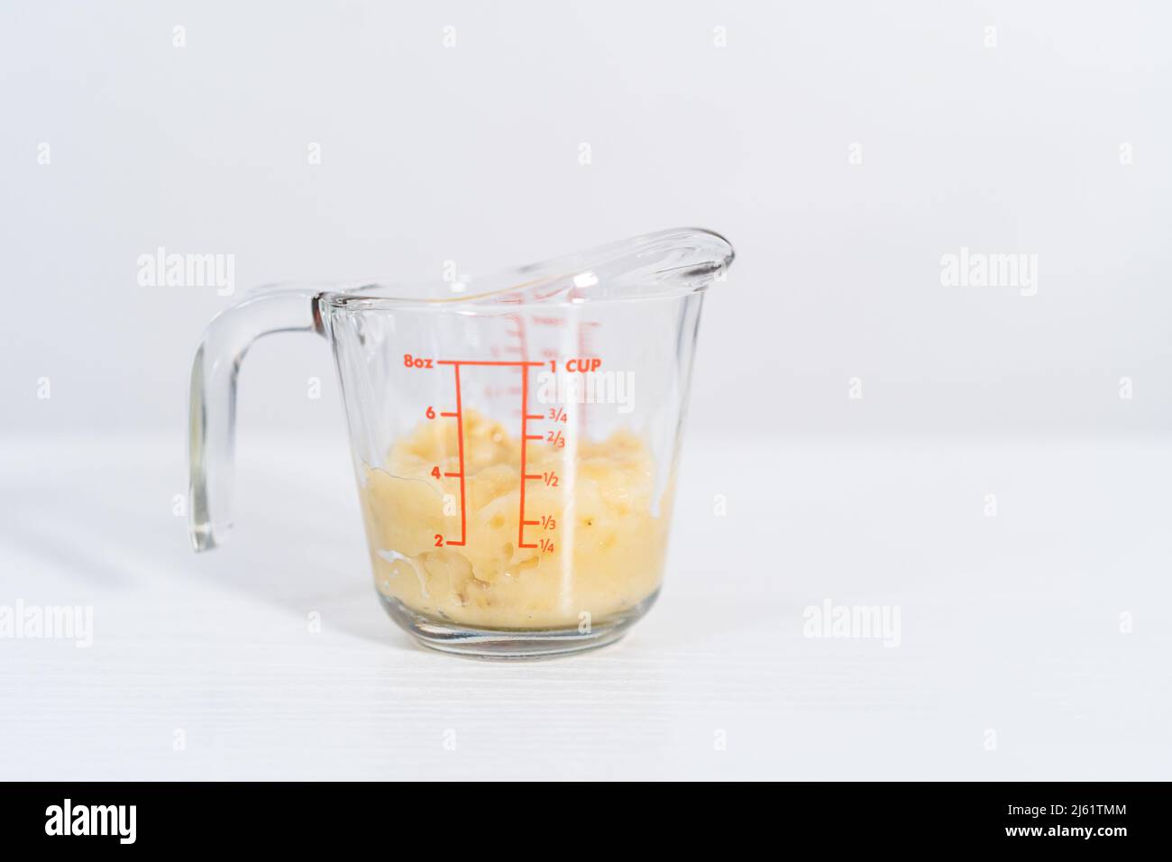 Mashed ripe banana in a glass measuring cup Stock Photo - Alamy