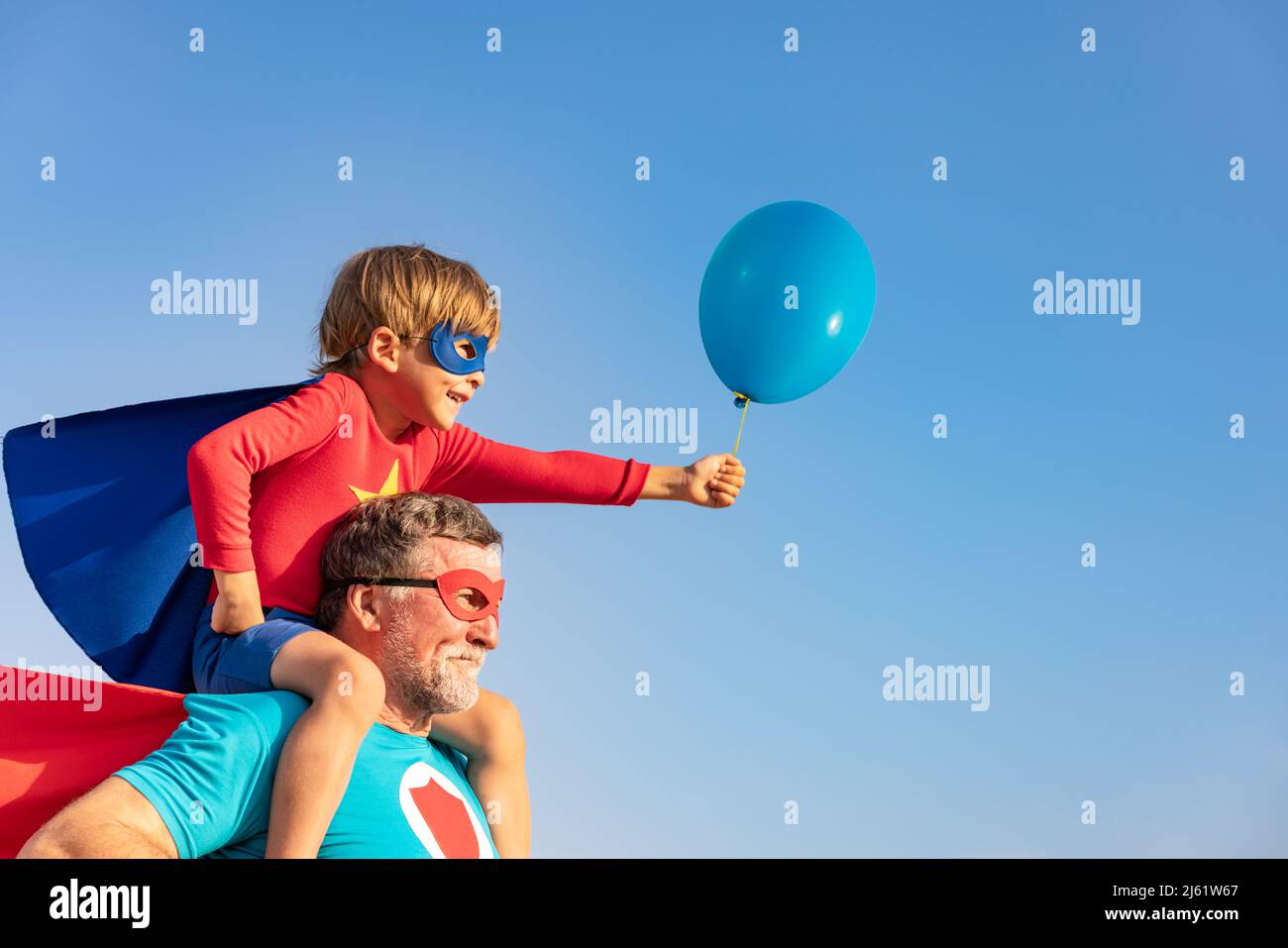 Superhero senior man and child playing outdoor. Super hero grandfather ...