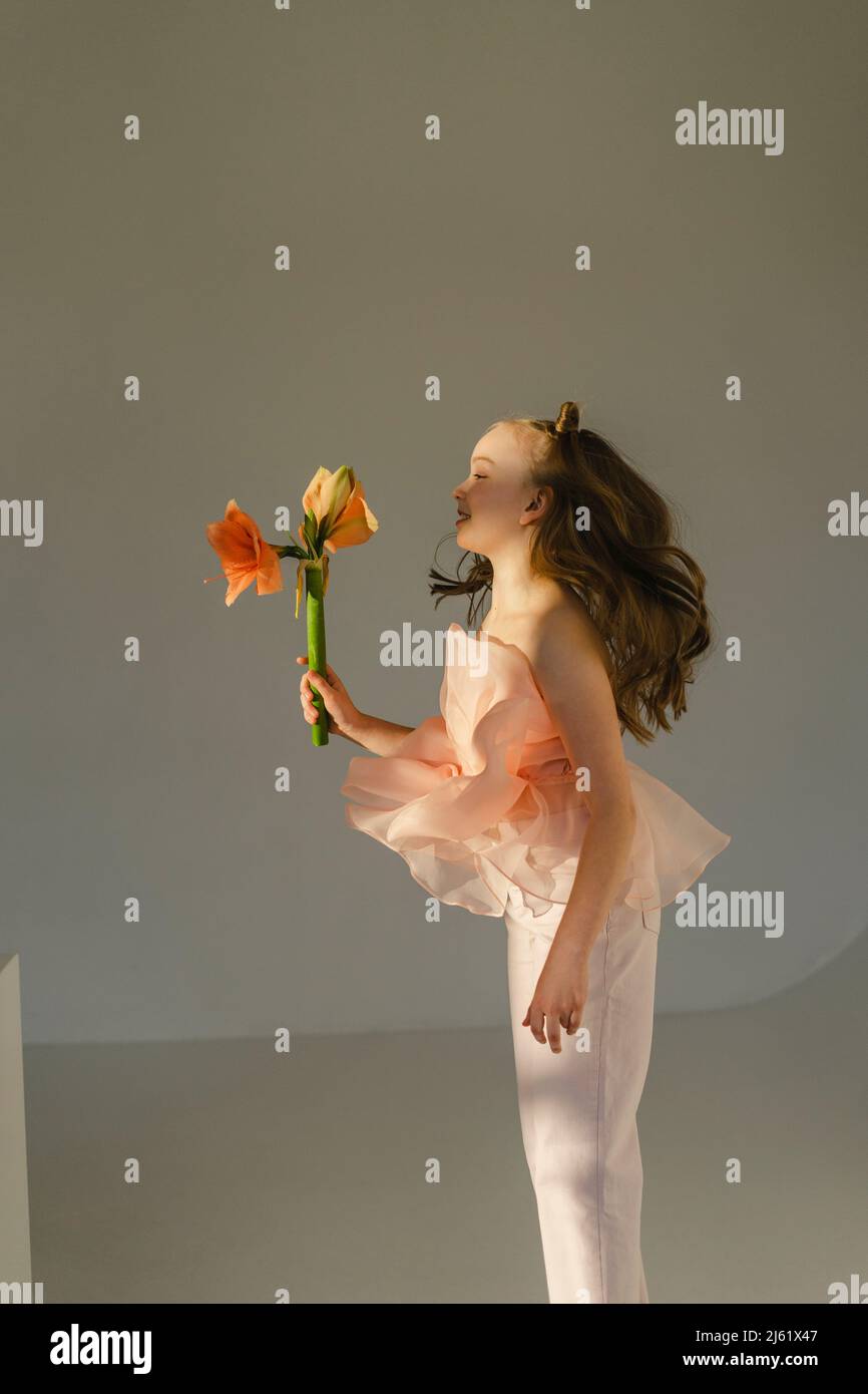 Cute girl jumping with flowers in hand Stock Photo - Alamy