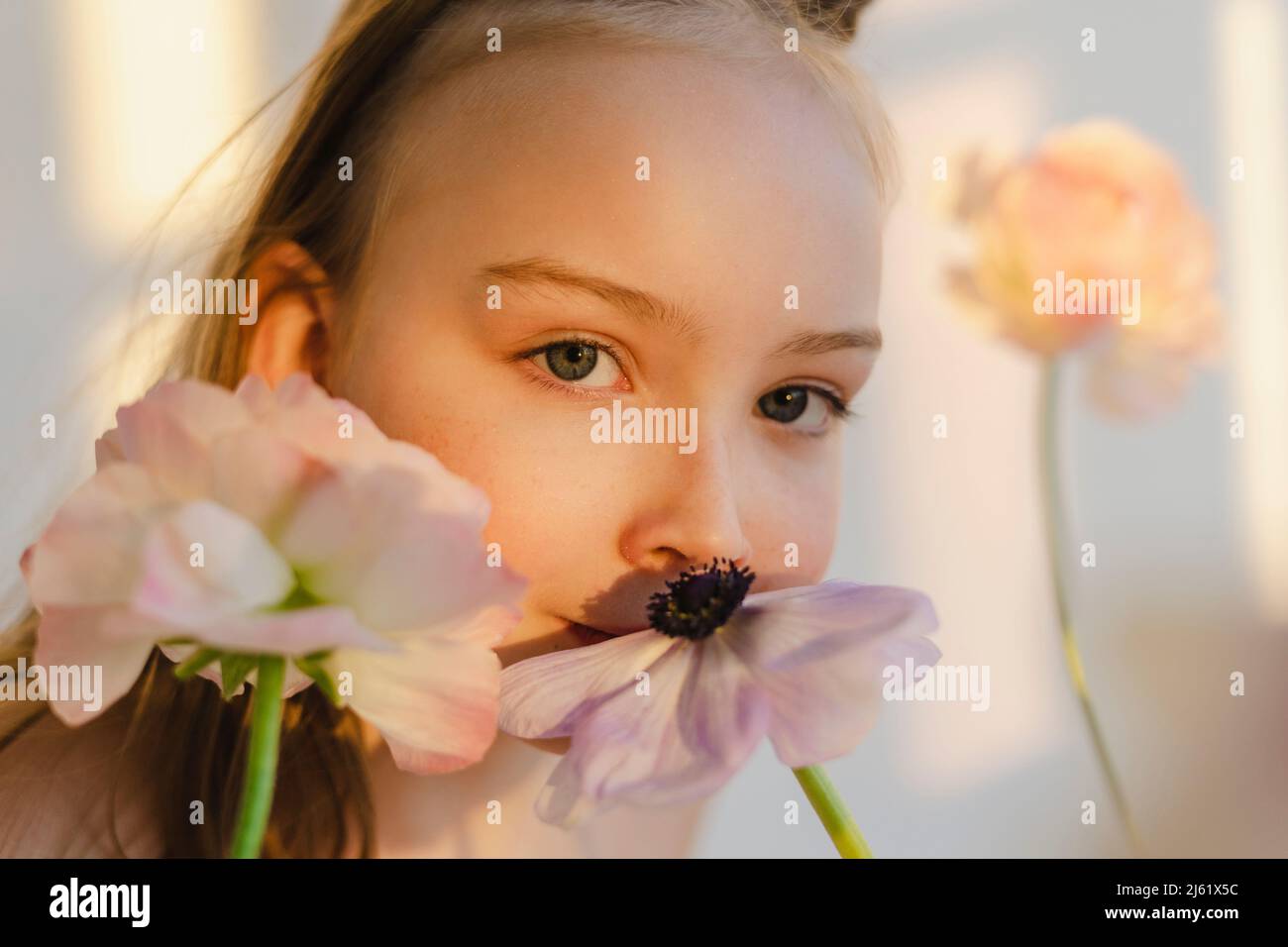 Cute girl smelling fresh flowers Stock Photo - Alamy
