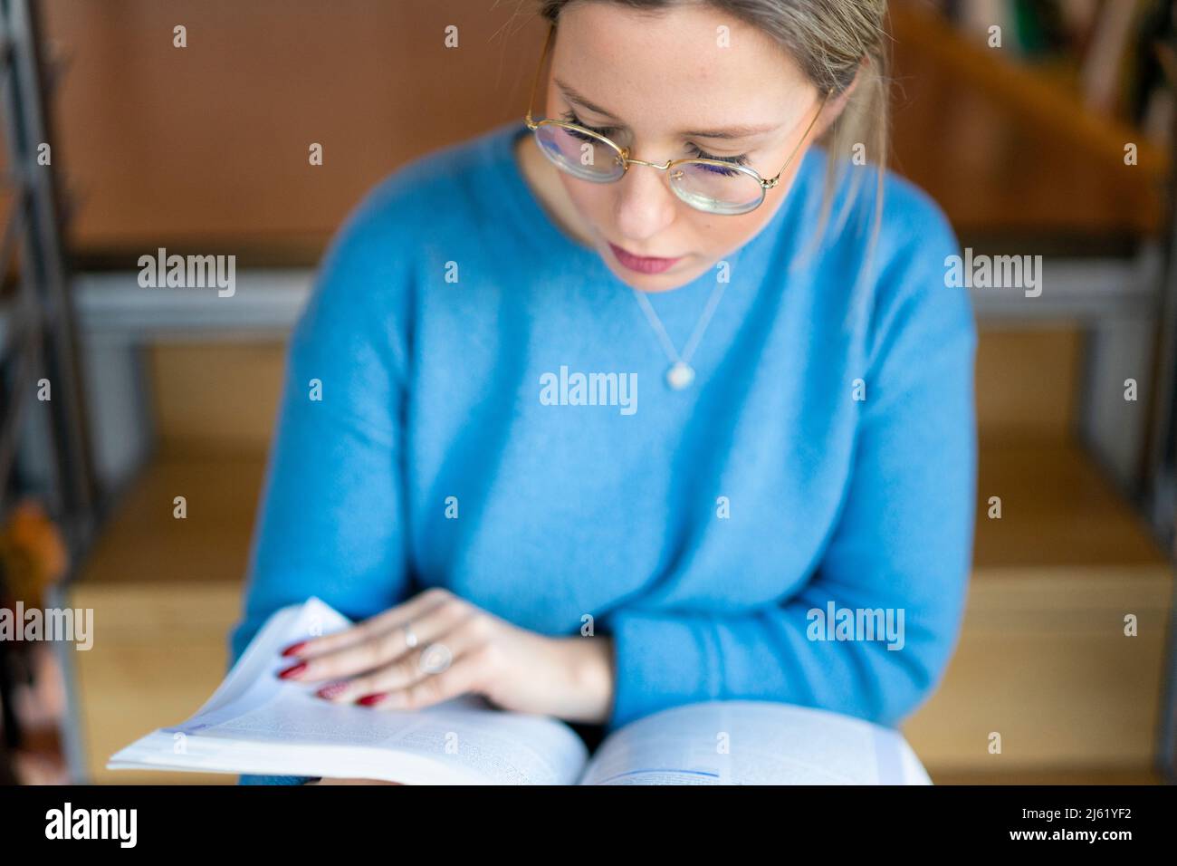 Young focused female reading book hi-res stock photography and images ...
