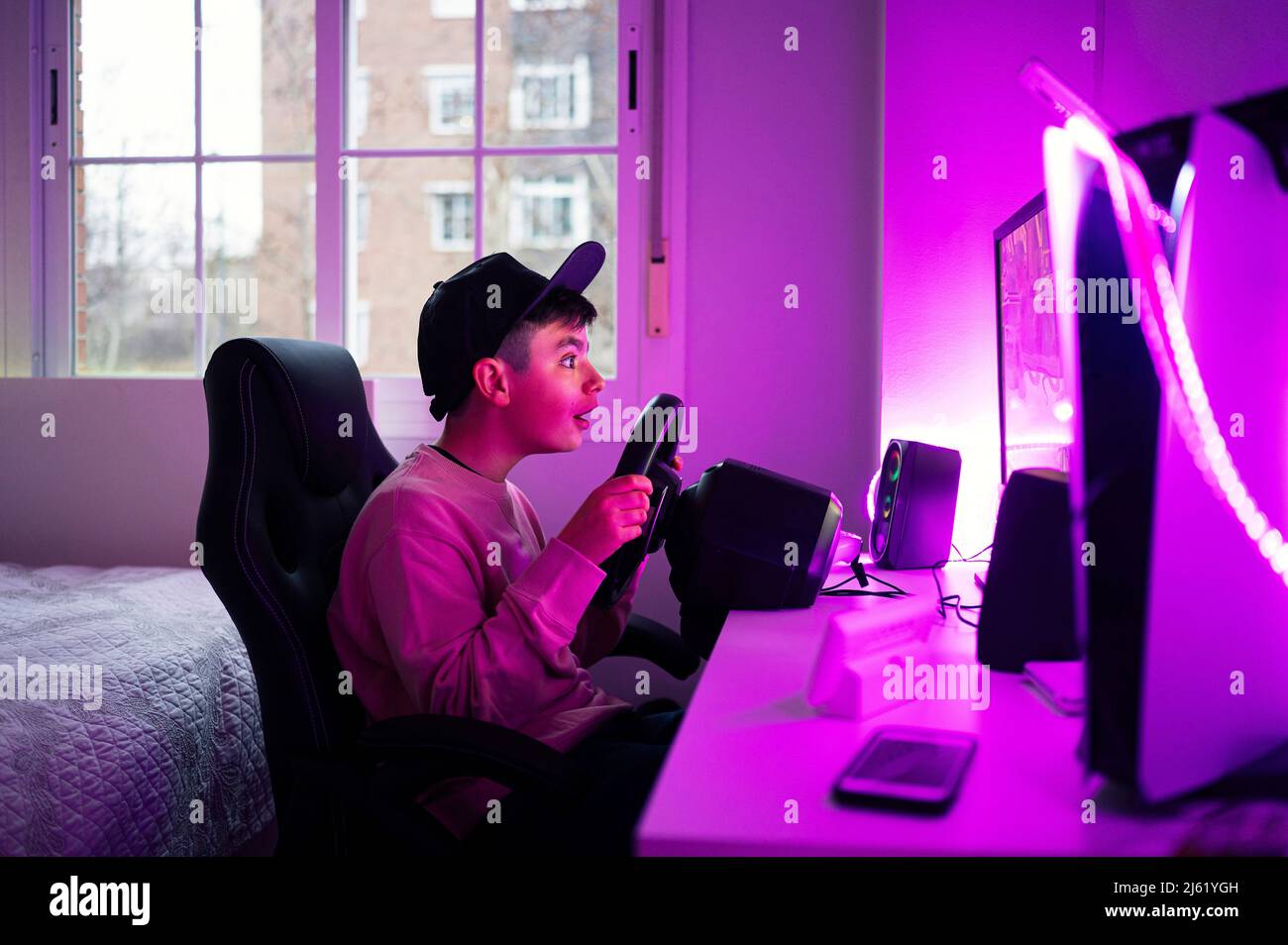 Surprised boy playing video game on computer in bedroom at home Stock ...