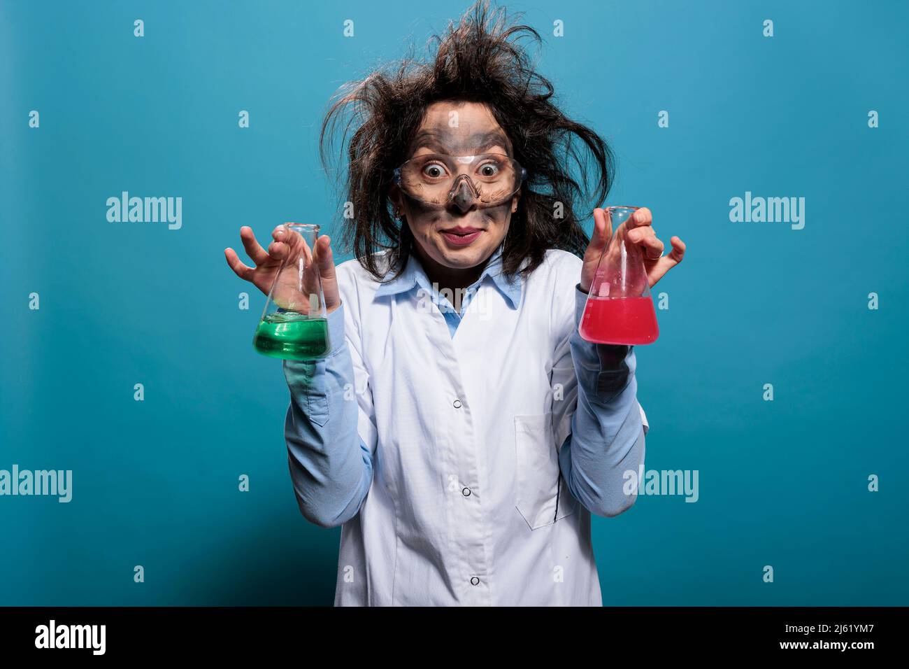 Crazy chemist holding glass flasks filled with toxic chemical compounds ...