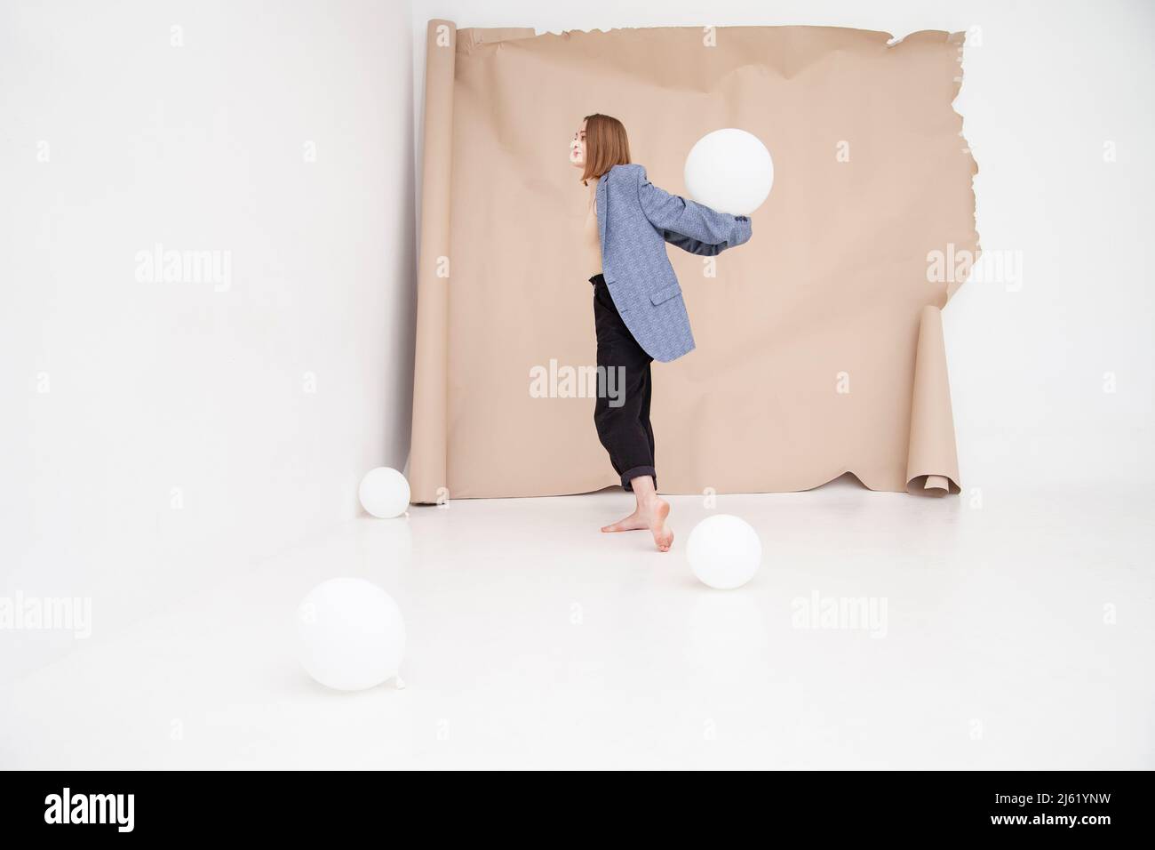 Young woman balancing balloon on hands by brown backdrop Stock Photo ...