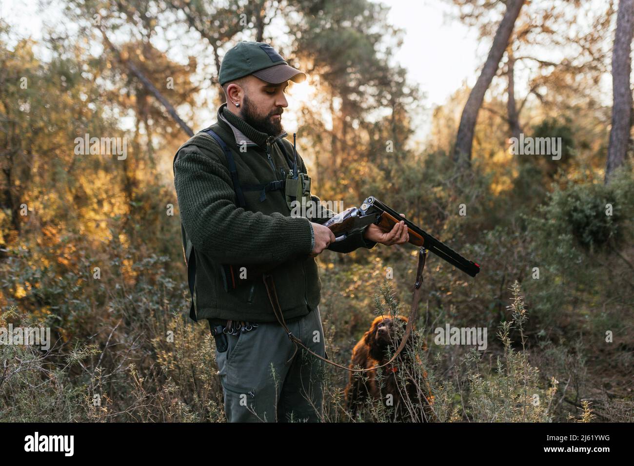 Hunter opening his hunting shotgun and watching cartridge in nature ...