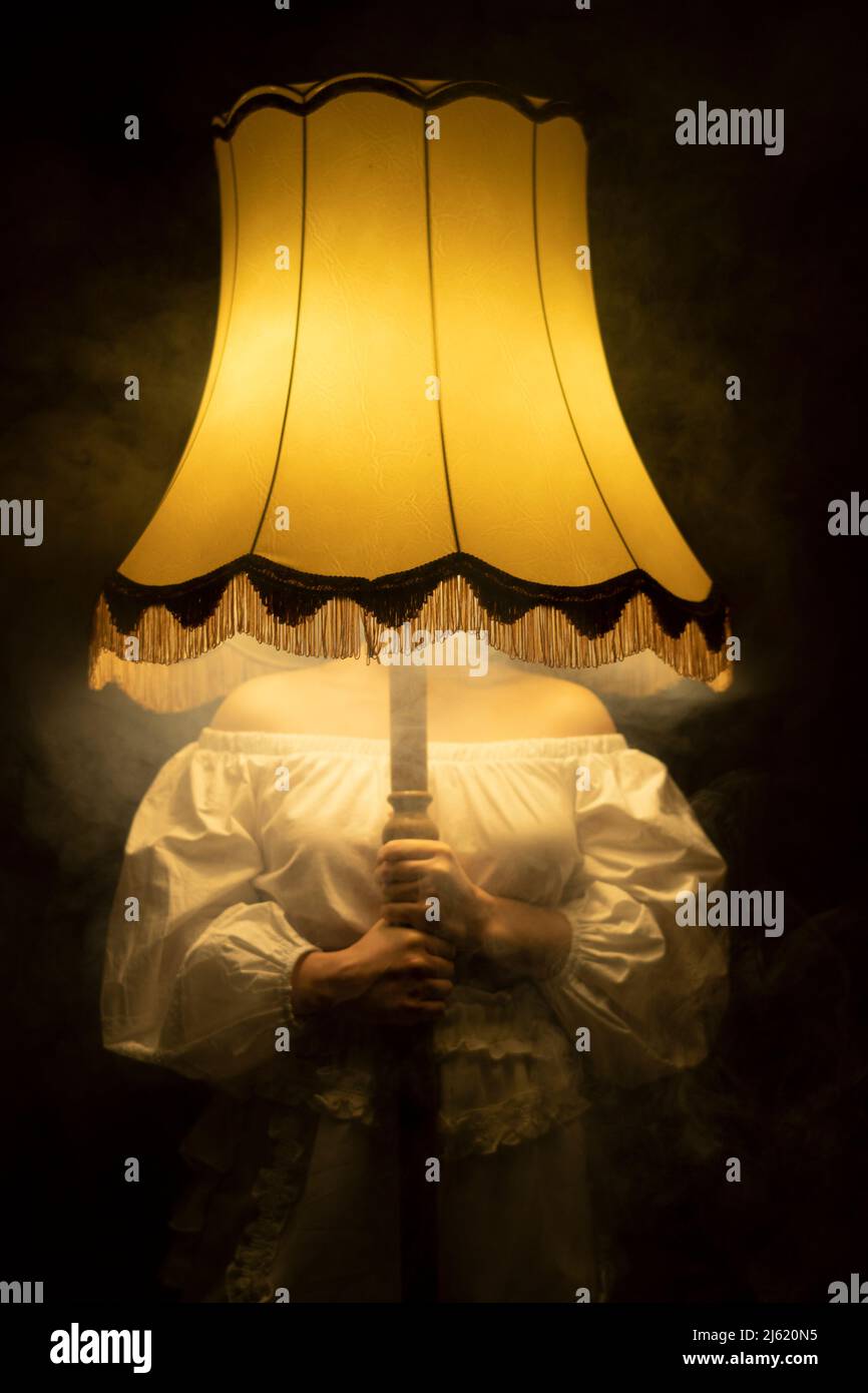 Woman holding illuminated smoky lamp in front of face Stock Photo - Alamy