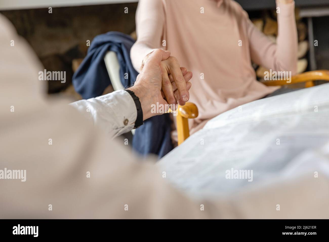 Man holding woman hand sitting on chair at home Stock Photo - Alamy