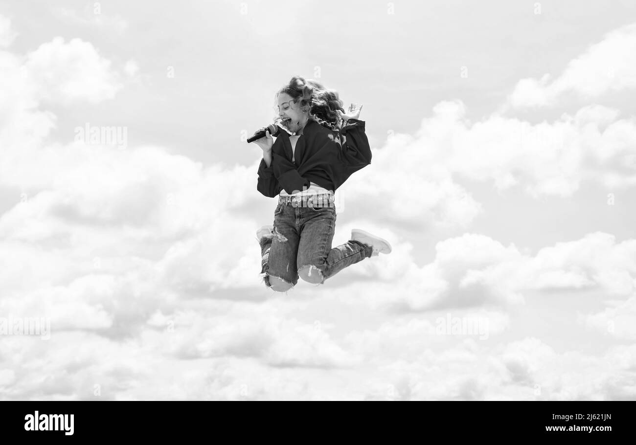 teen kid jumping and singing with microphone in karaoke. child singing ...