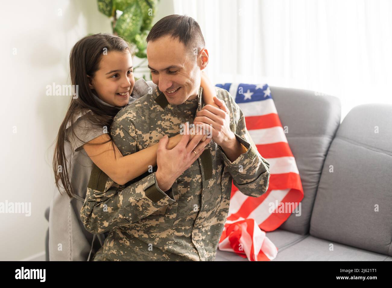 a child girl hugs a military father. dad in military uniform with his ...