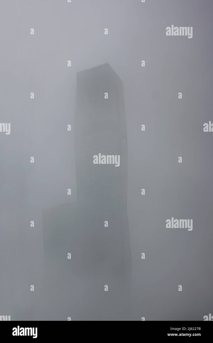 A tall skyscraper building in thick fog Stock Photo - Alamy