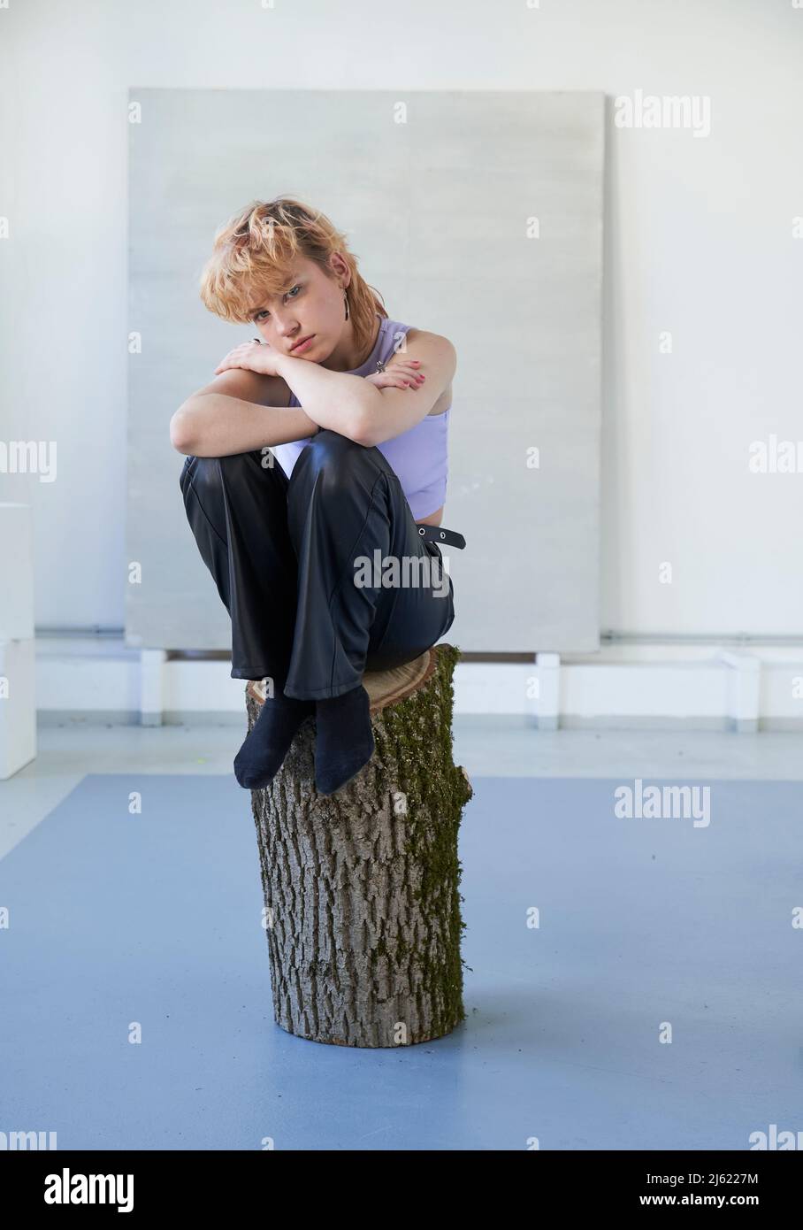 Young woman sitting on tree log hi-res stock photography and images - Alamy