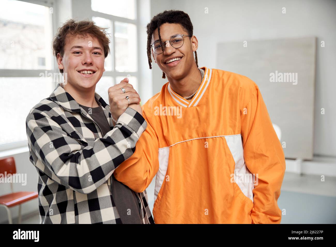 Two friends shaking hands smiling hi-res stock photography and images ...