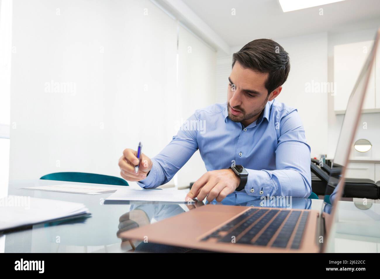 Patient signing paper at desk in aesthetic clinic Stock Photo - Alamy