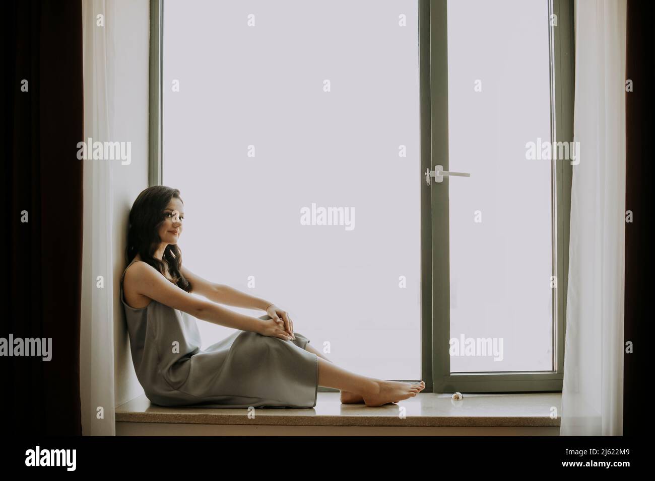 Young woman sitting window home hi-res stock photography and images - Alamy