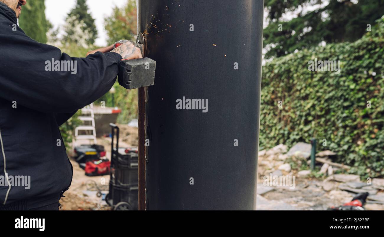 Worker using grinder working on construction site Stock Photo - Alamy