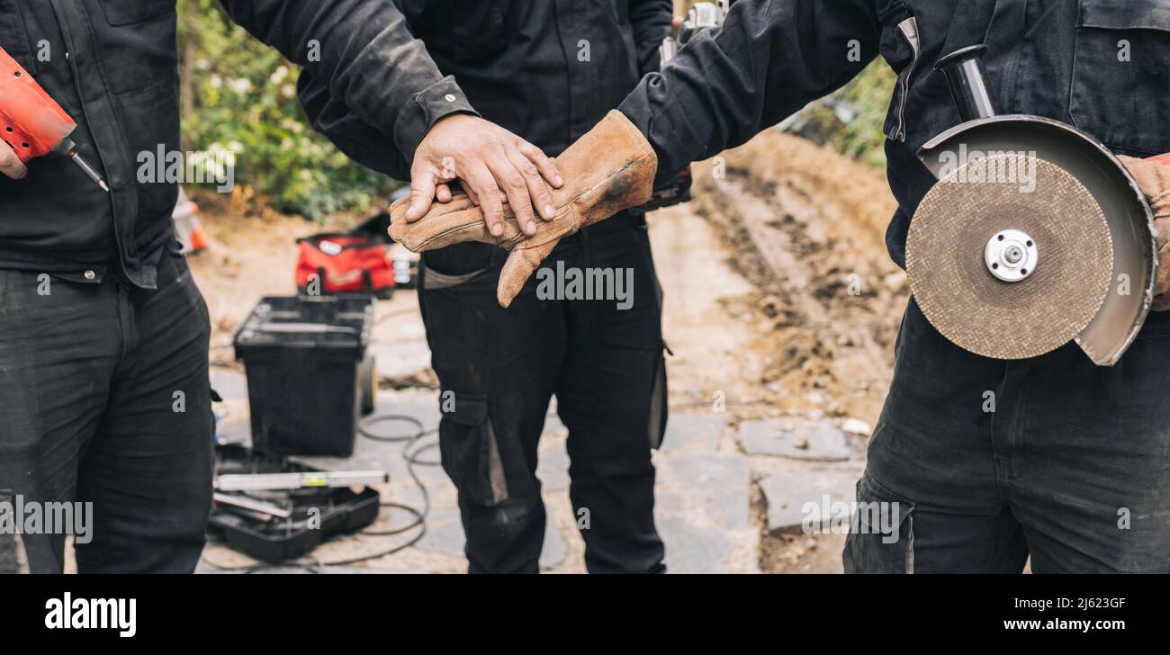 Construction workers stacking hands at construction site Stock Photo ...